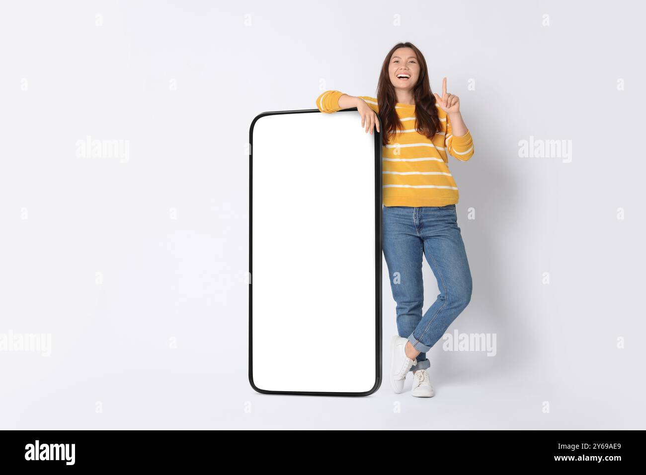 Happy smiling woman and big mobile phone with blank screen on white ...