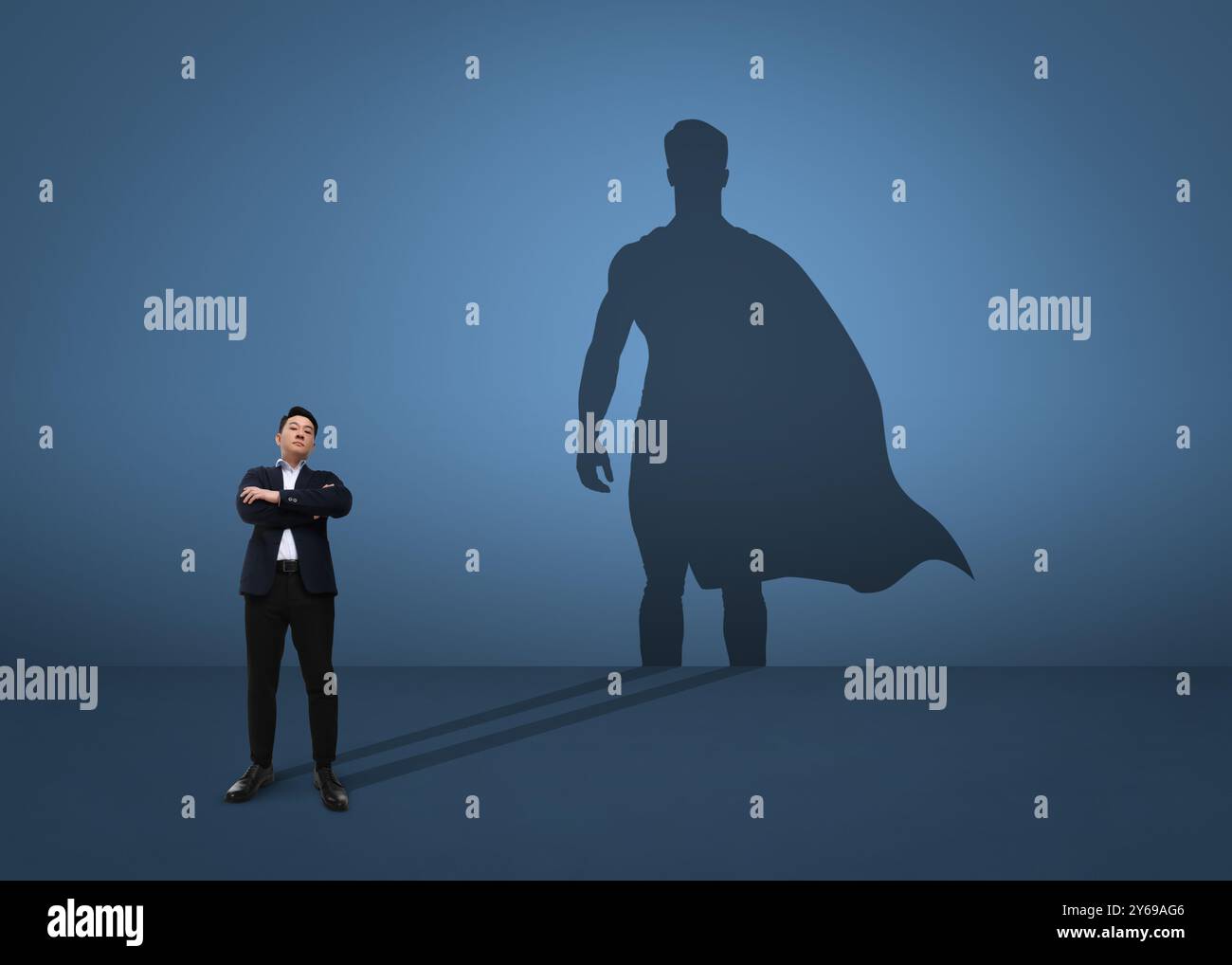 Confident businessman casting shadow of superhero on light blue ...