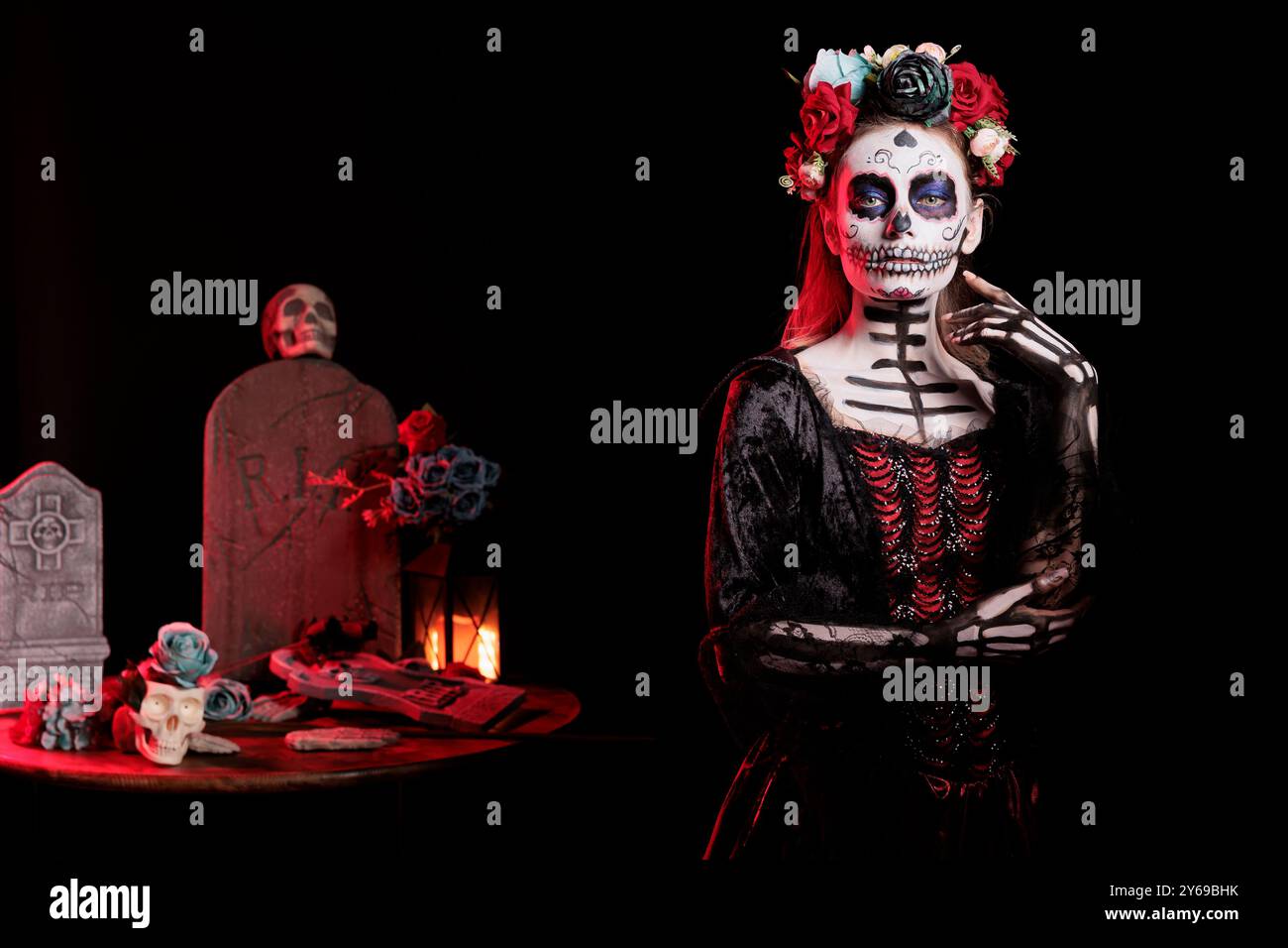 Woman dressed in Day of the Dead horror costume with flower headband ...