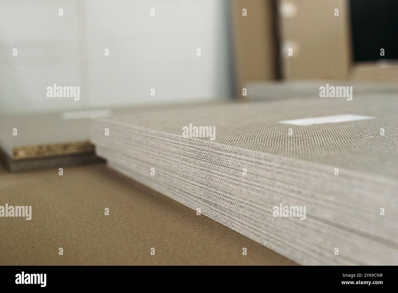 A close-up view of a stack of wood panels, likely for furniture ...