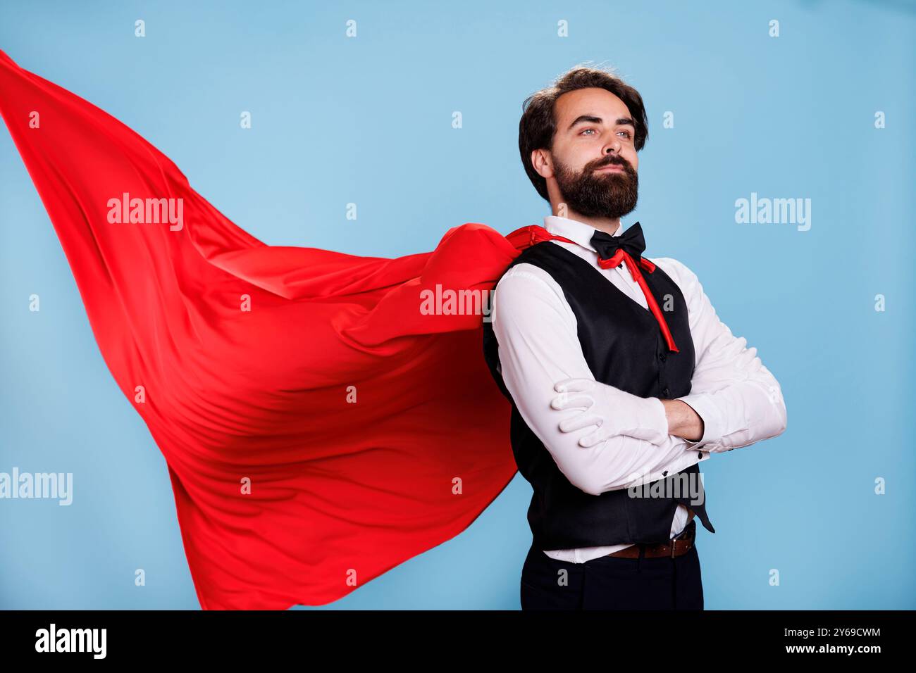 Strong man hero with red mantle standing against blue background ...