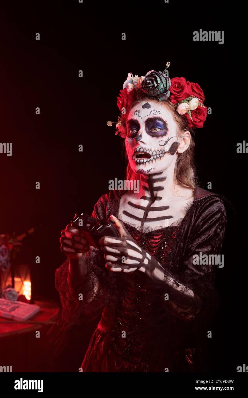 Woman playing games with gamepad, during Dia de los Muertes indigenous ...