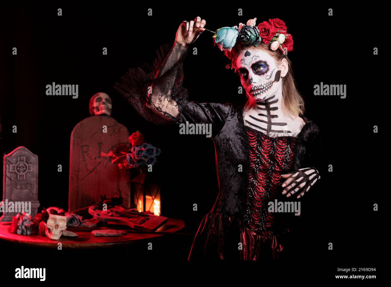 Woman wearing skeleton body paint art, celebrating Day of the Dead. Bizarre lady holding blue ...