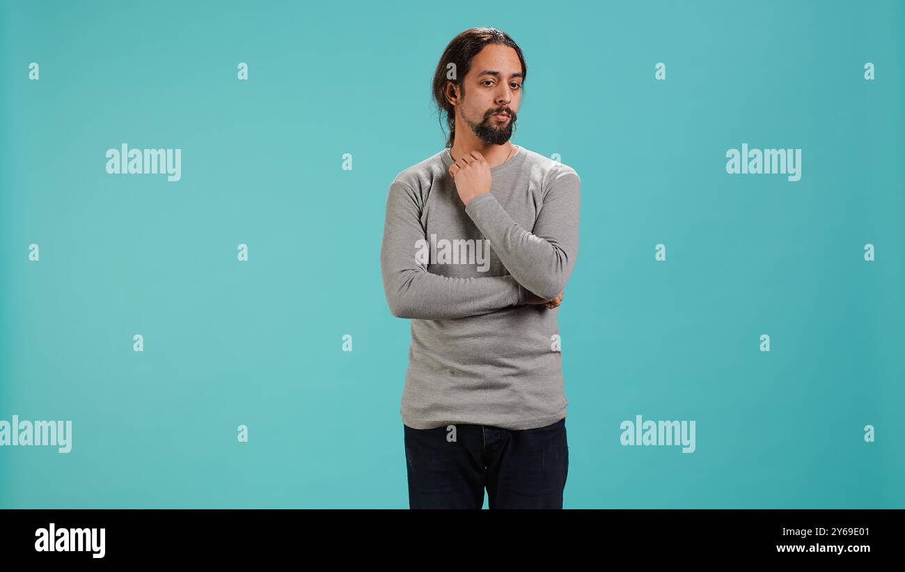 Portrait of man scratching neck with fingers, listening for unfamiliar ...