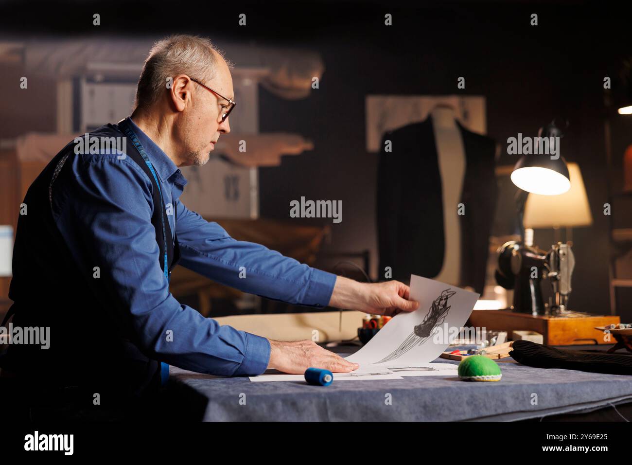 Creative elderly fashion designer creating outfits for upcoming fashion ...