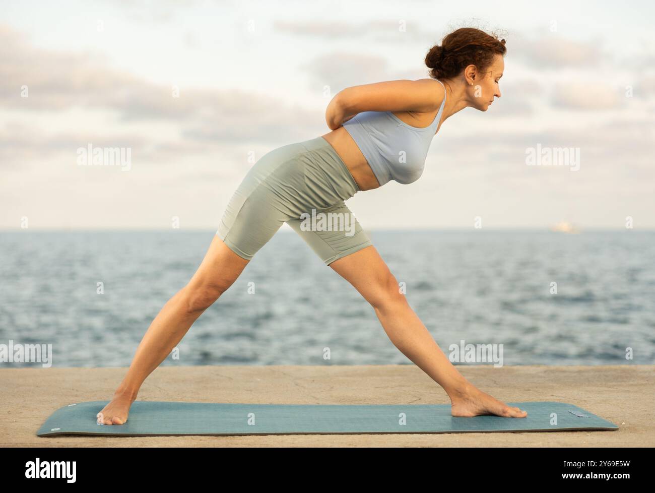 Yoga practice on embankment, female athlete fulfil carry out ...