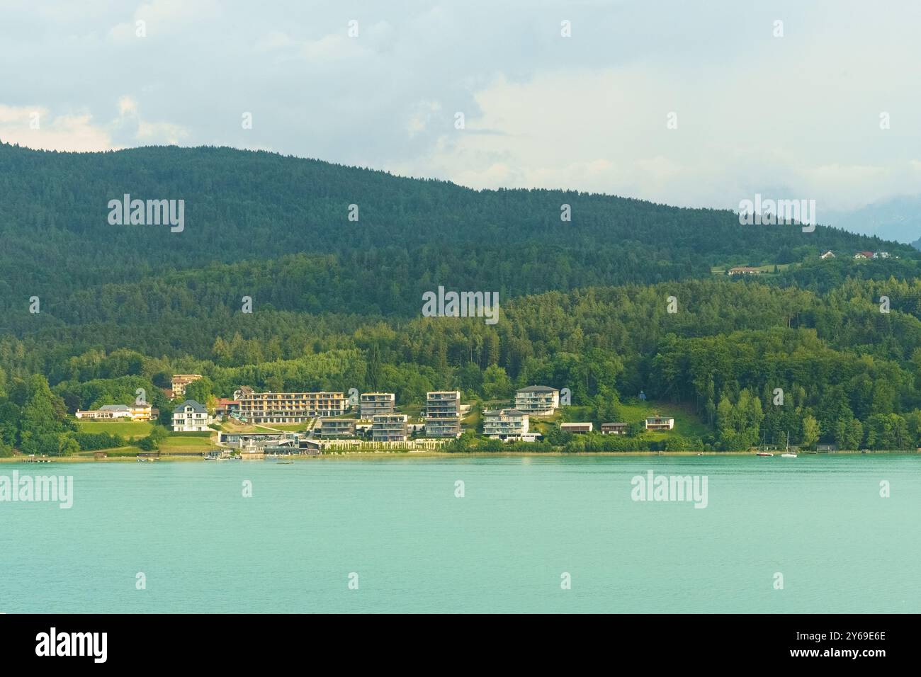 A peaceful lakeside resort emerges from the greenery, surrounded by ...