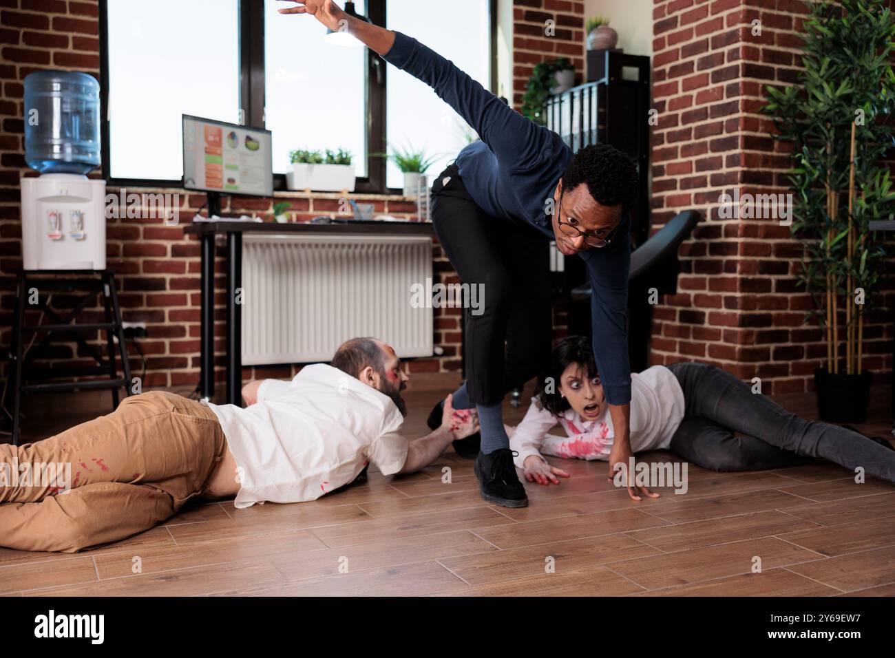 Actors playing zombies in horror movie scene grabbing BIPOC employee to ...