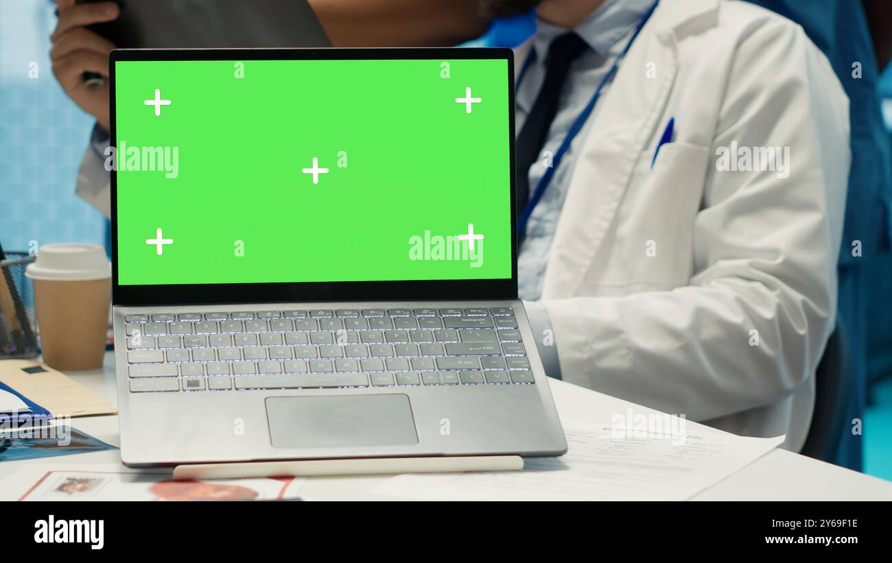 Group of doctors consulting hospital records next to chroma key display ...