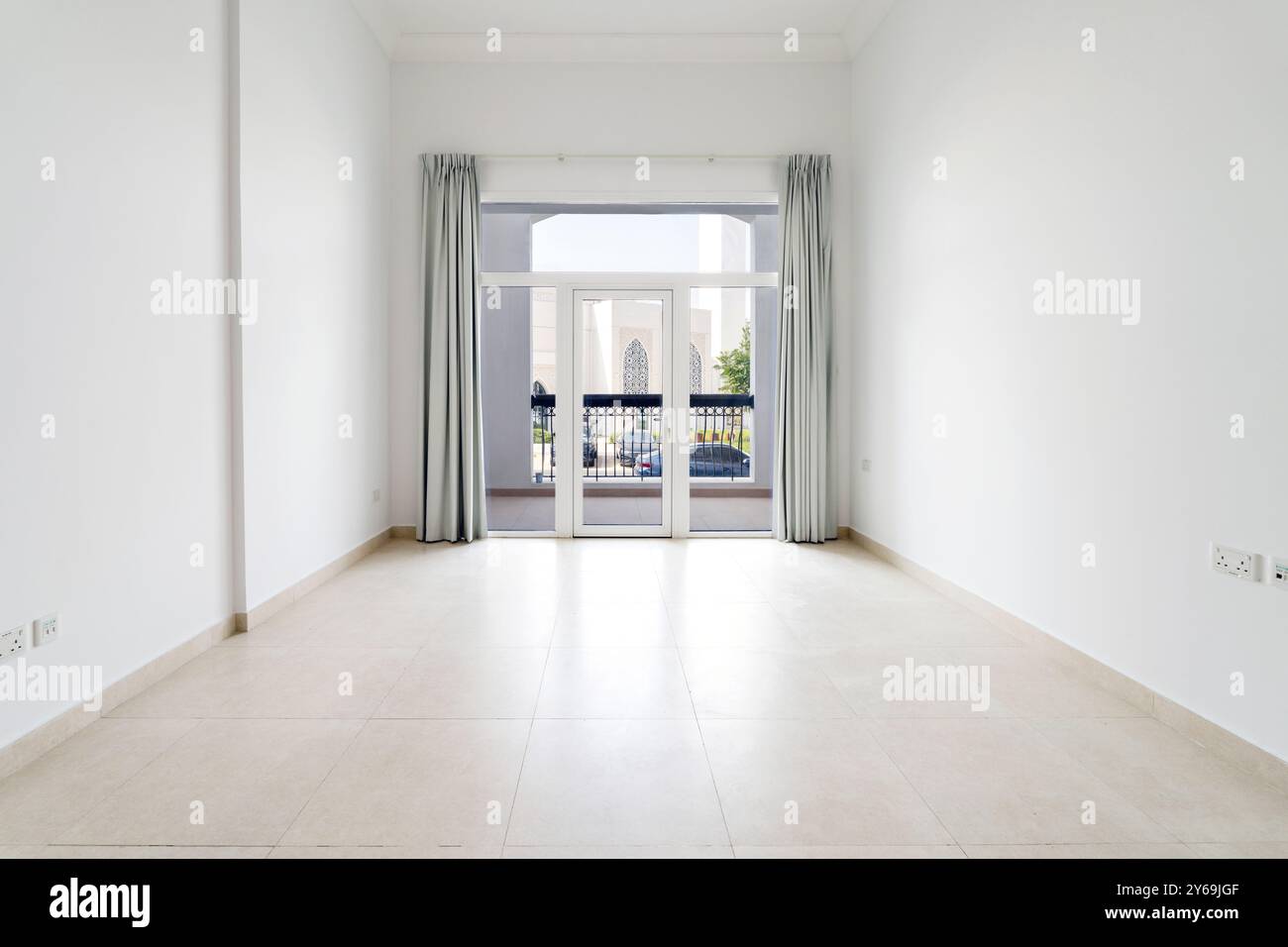 A clean, empty room with glossy tiled floors and white walls. A large ...