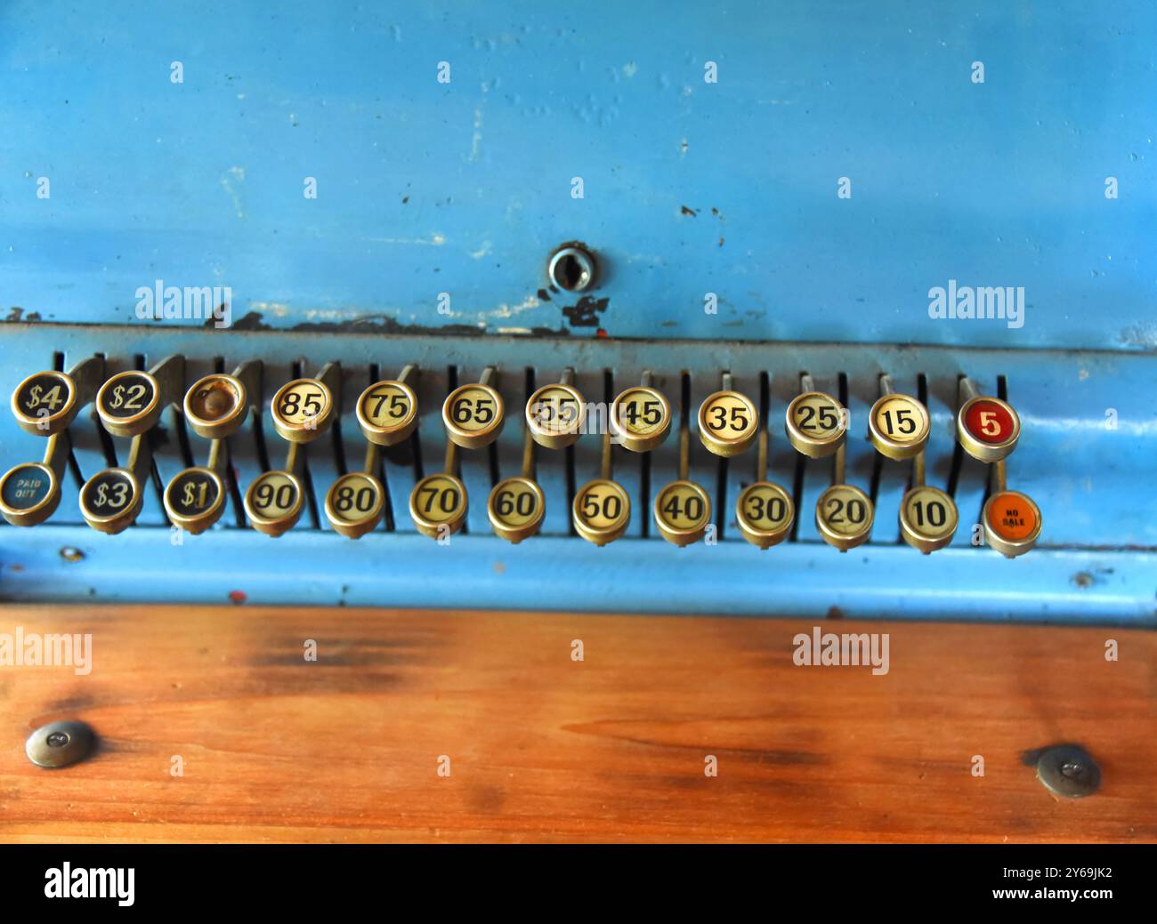 Closeup image shows black numbered keys on an antique, blue cash ...