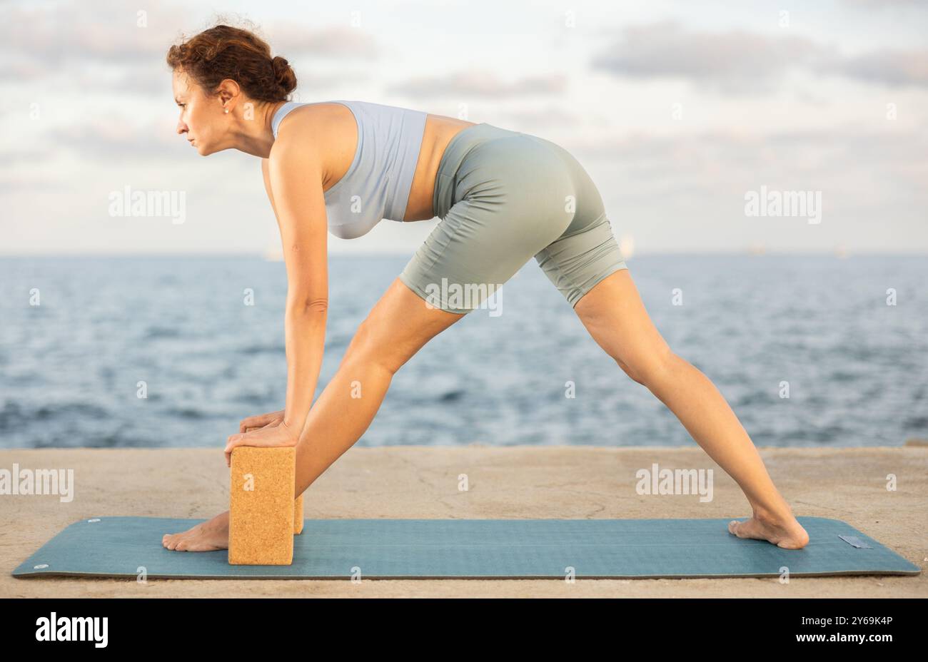 Female yoga instructor performing various asana poses using rectangular ...