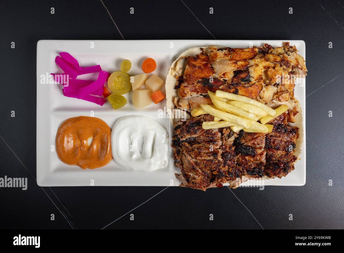 Chicken and beef Shawarma plate served with fries, pickles and sauces ...