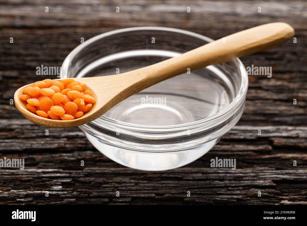 Red lentils in a spoon and clean water in a bowl - Lens culinaris Stock ...