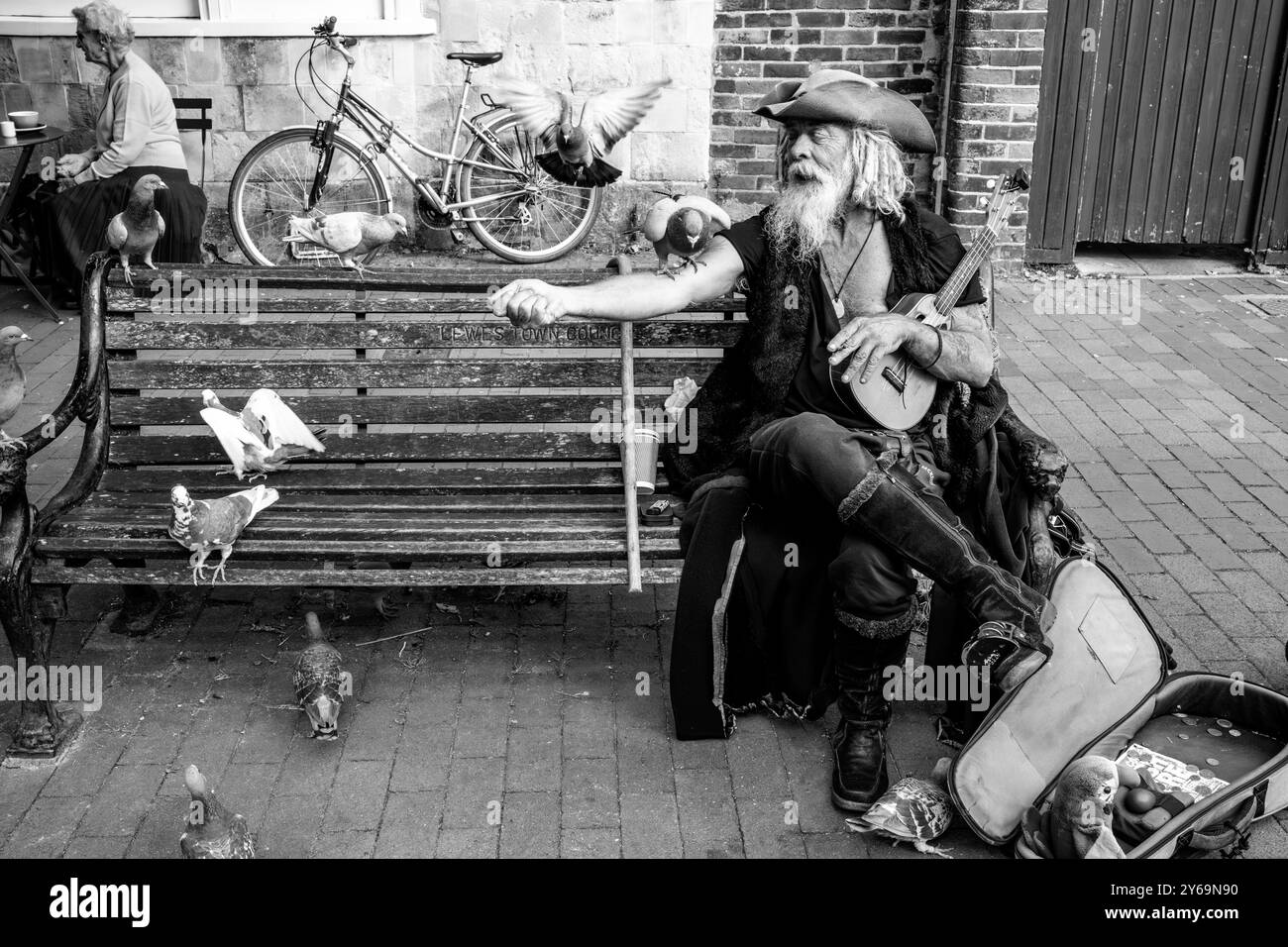 A Street Entertainer In A Pirate Costume Sits On A Public Bench Feeding ...