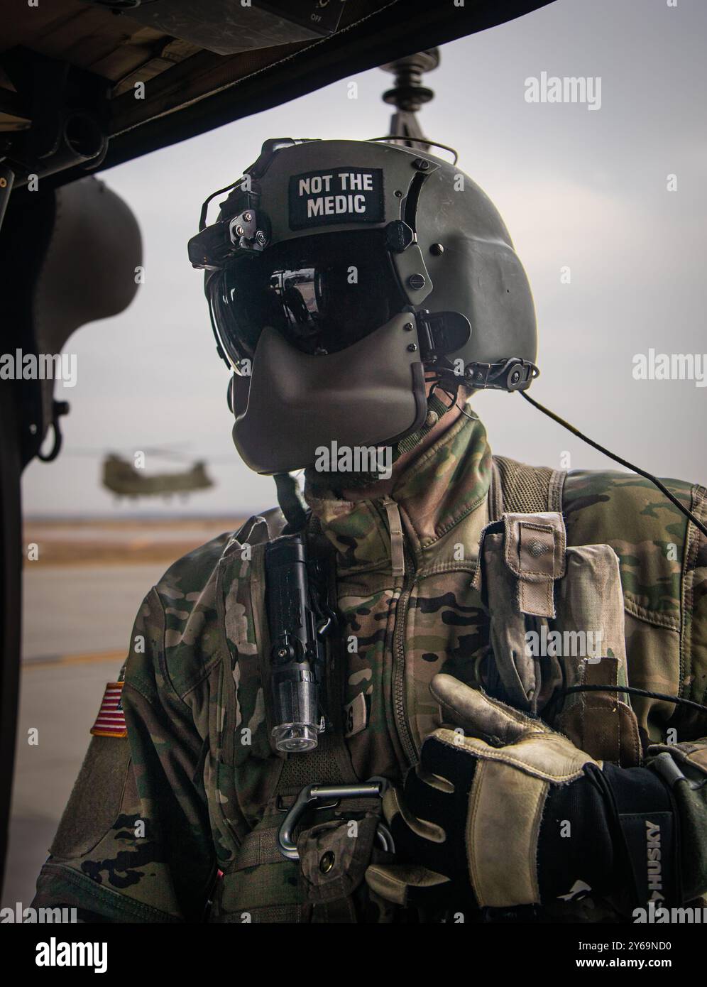 A 4th Combat Aviation Brigade crew chief conducts preflight checks on a ...