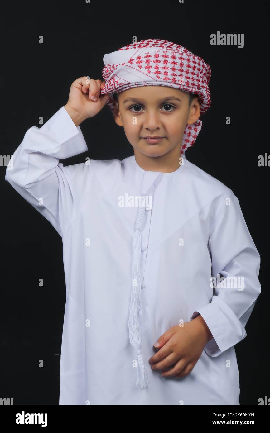 Young boy, white kandura, black agal on ghutra, traditional UAE Arabian ...
