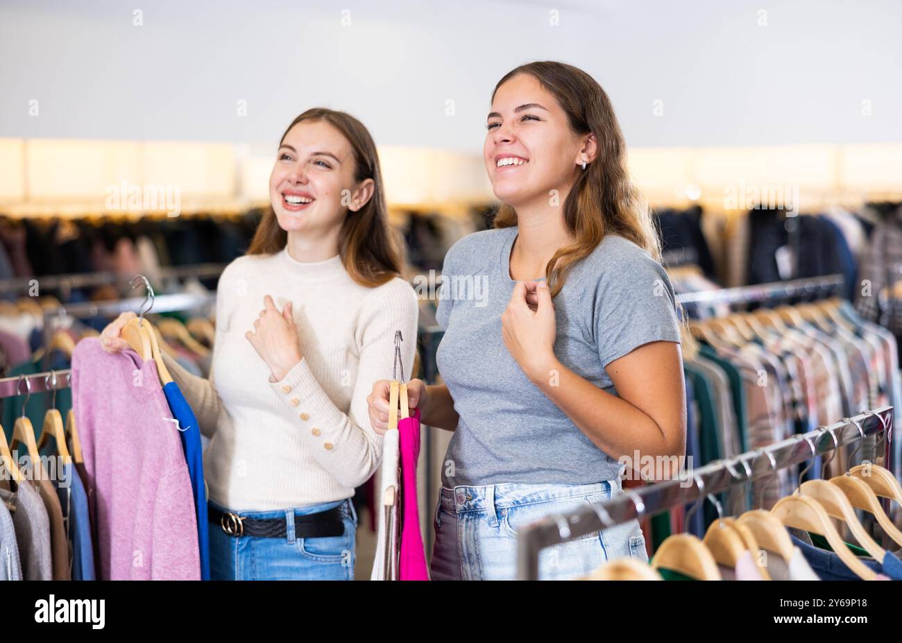 Two happy female friends are shopping in clothing store. Shopping young ...