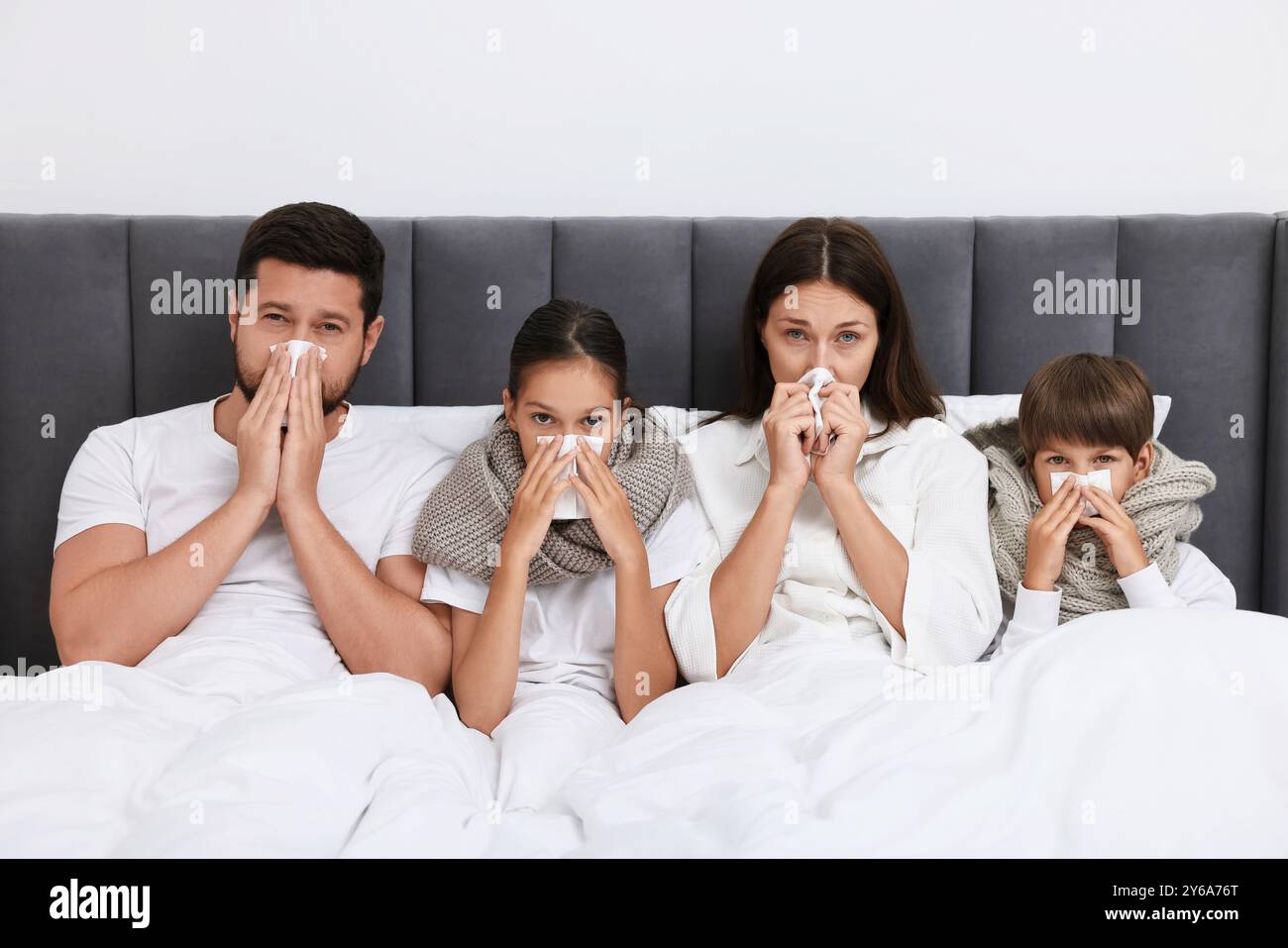 Cold symptom. Family suffering from fever in bed at home Stock Photo ...