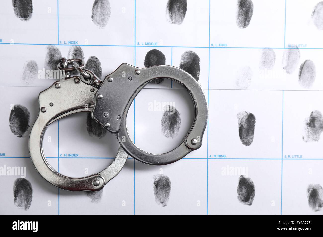 Human fingerprints and handcuffs on paper, top view. Criminal ...