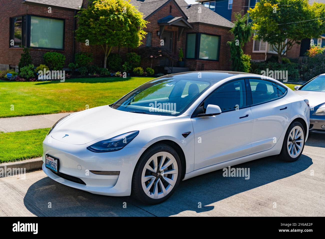 Seattle, WA, USA -July 3, 2024: tesla model 3 white near luxury house ...