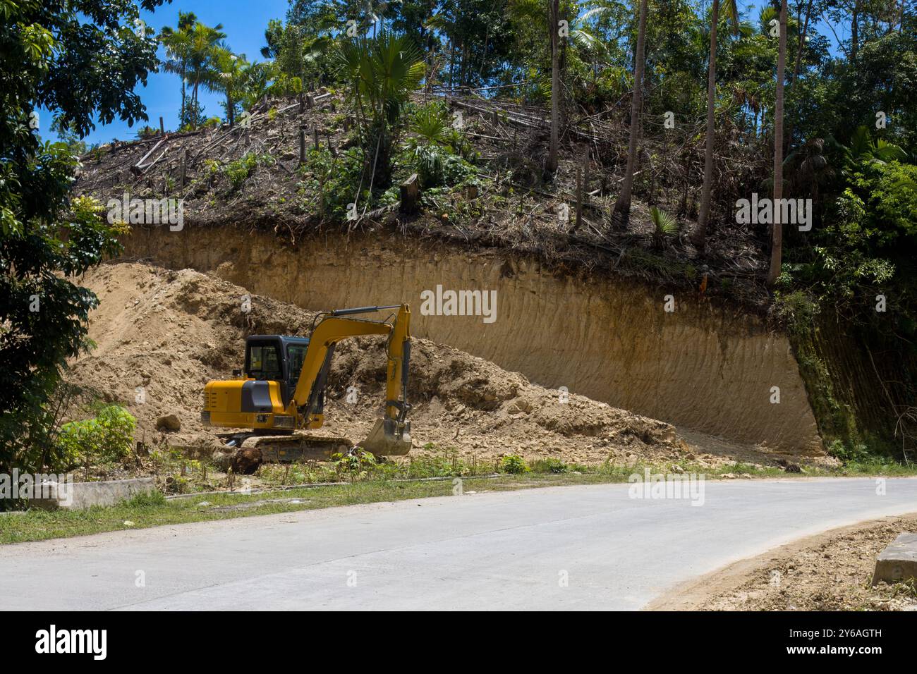 Excavator on the construction of a road through the tropical jungle ...