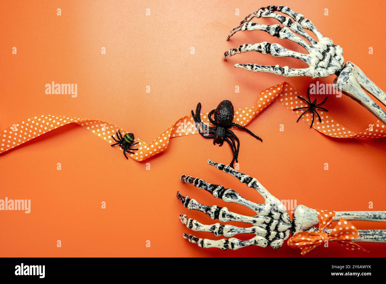 Halloween decorations with skeleton hands and spiders on an orange ...