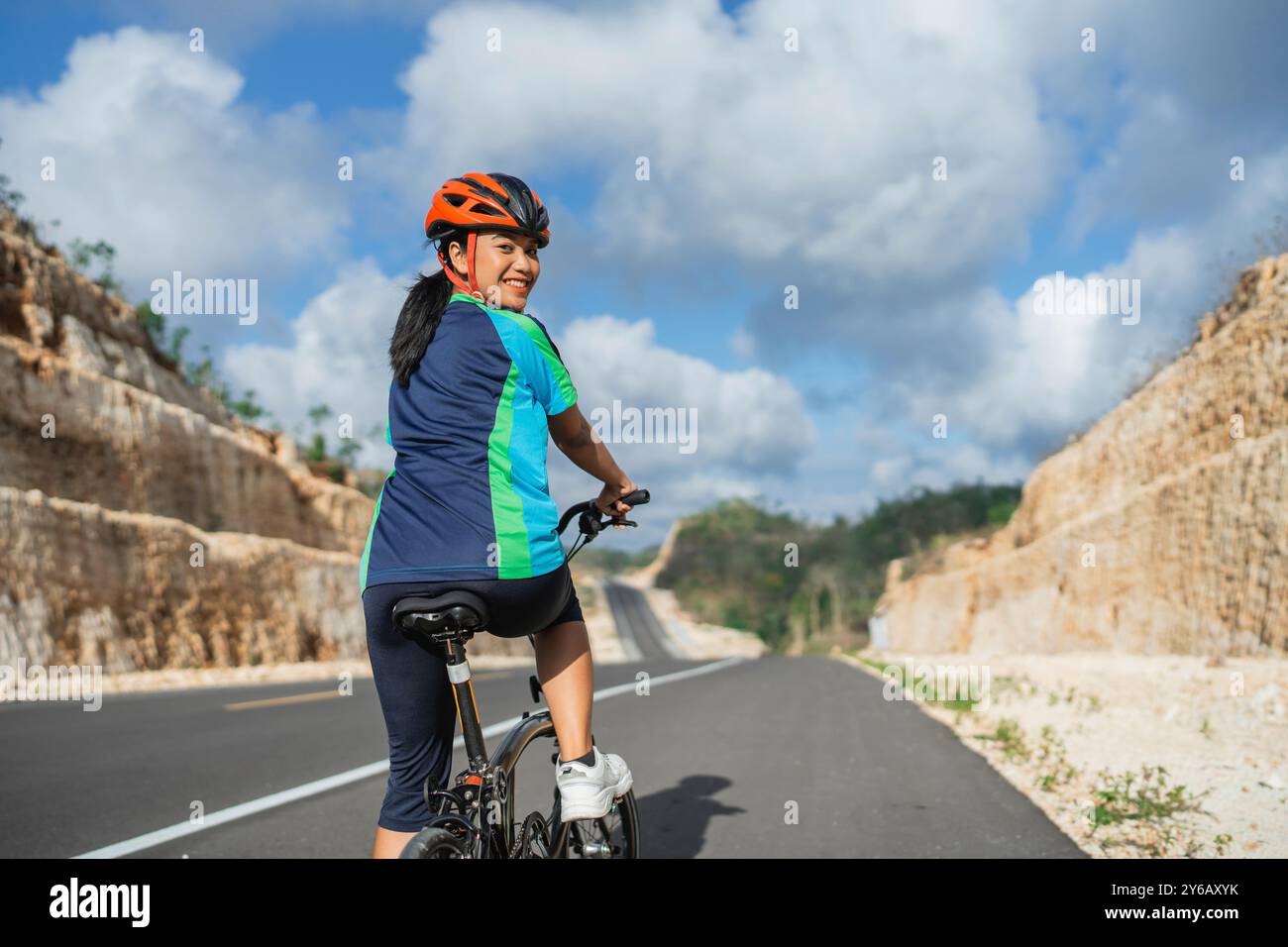 back view female biker riding bike Stock Photo - Alamy