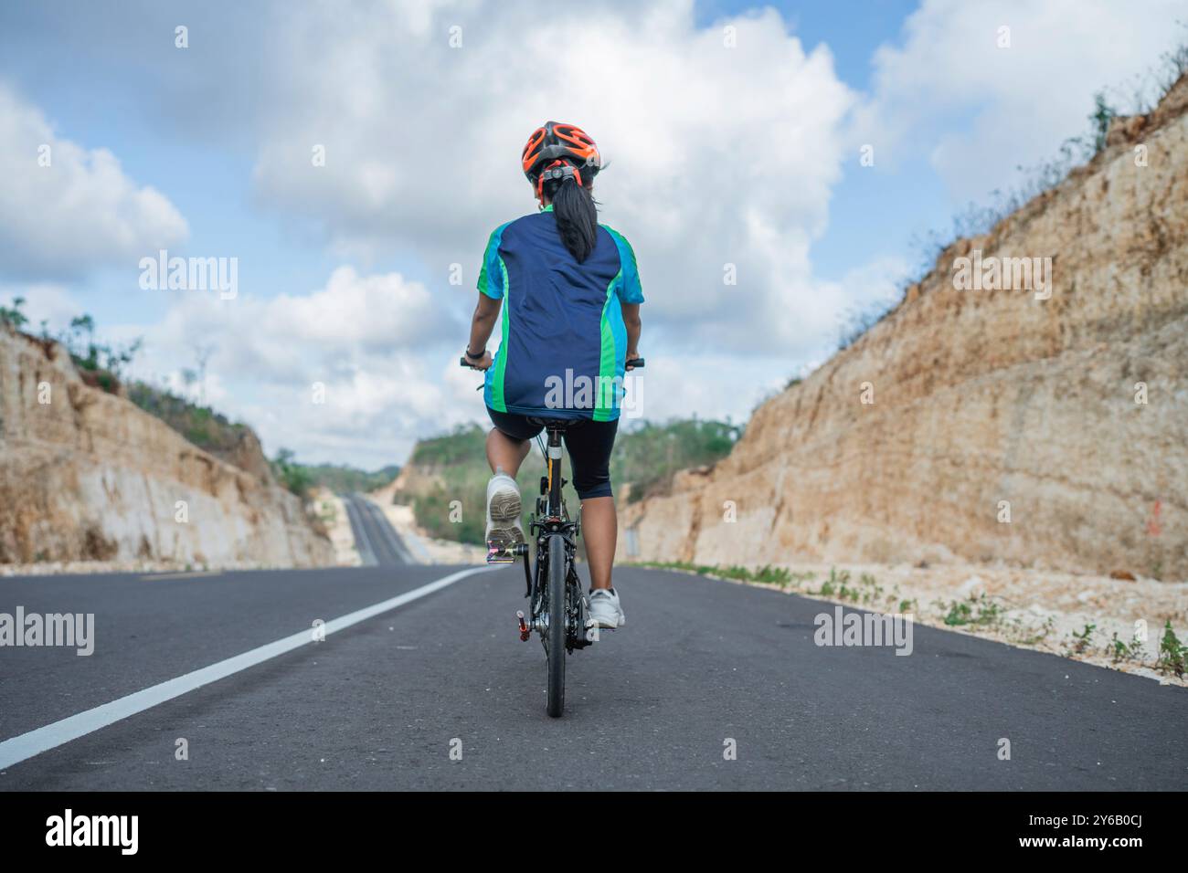 rear view female biker enjoying riding bike Stock Photo - Alamy
