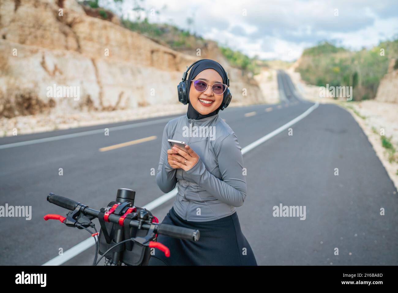 female biker using earphone and phone when biking Stock Photo - Alamy