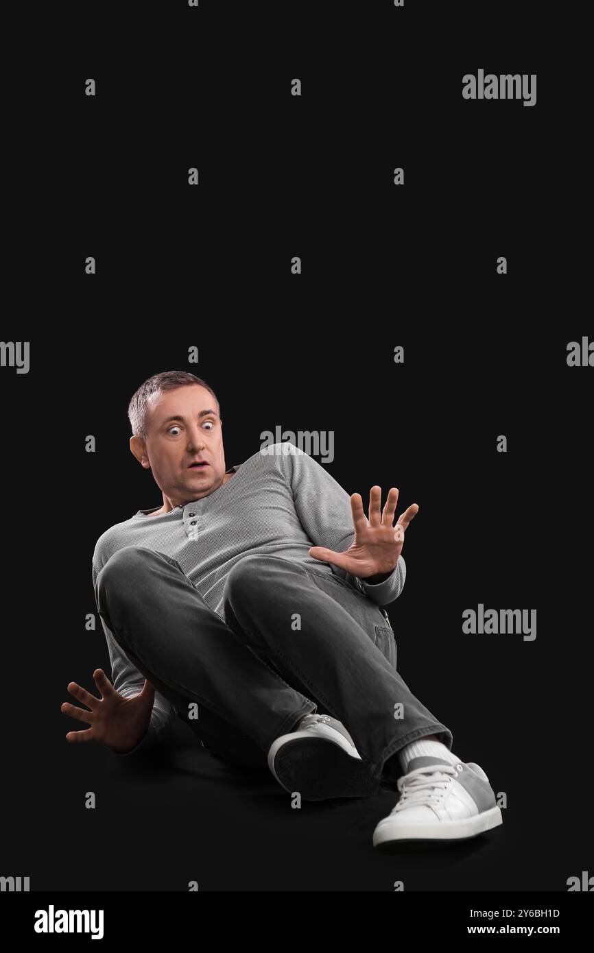 Scared mature man on black background Stock Photo - Alamy