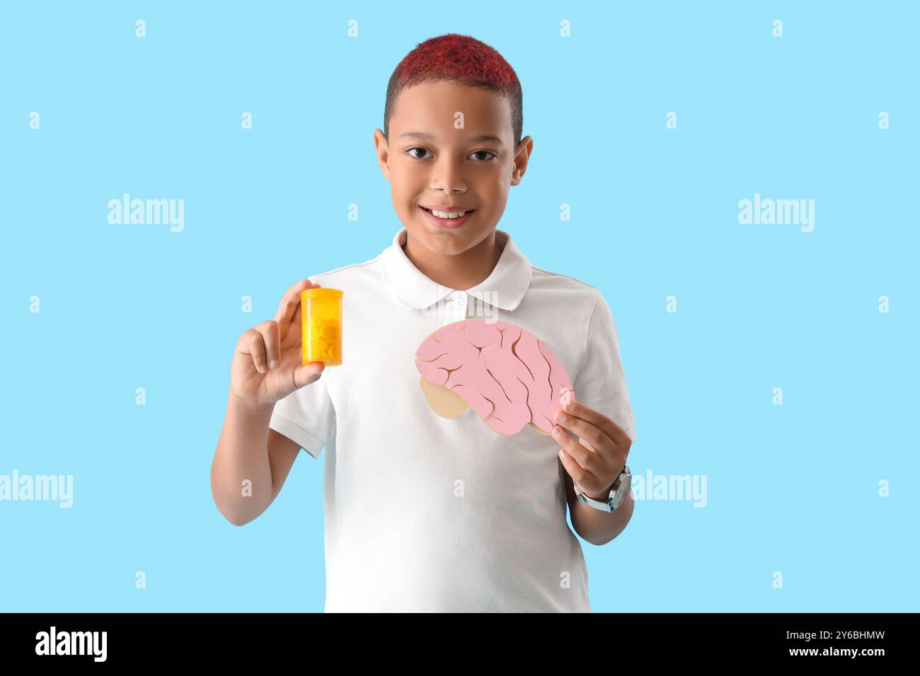 Little African-American boy with paper brain and pill bottle on blue ...