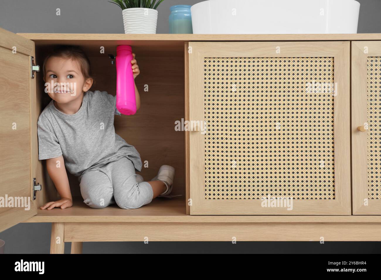 Cute little girl with detergent sitting in commode. Child at risk Stock ...