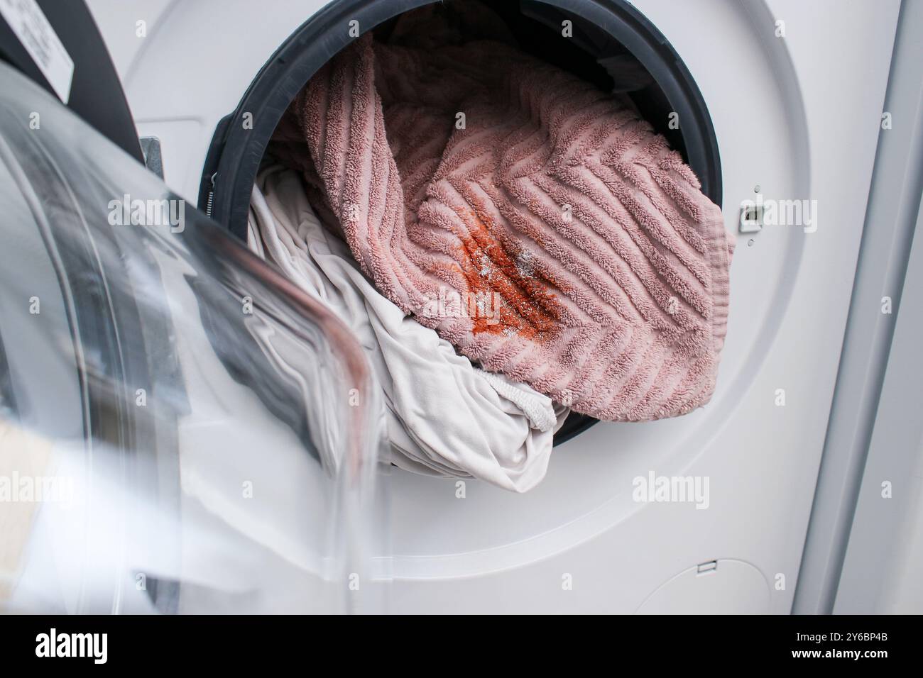 Dirty cloth with a red spot in a washing machine Stock Photo - Alamy