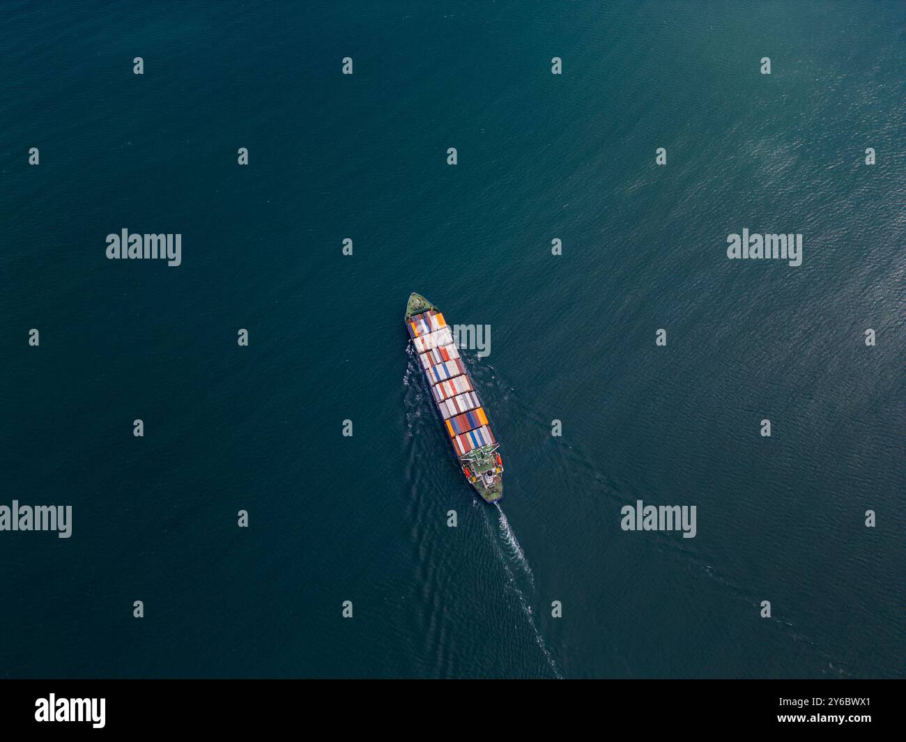 A container ship sails across the calm blue waters Stock Photo - Alamy