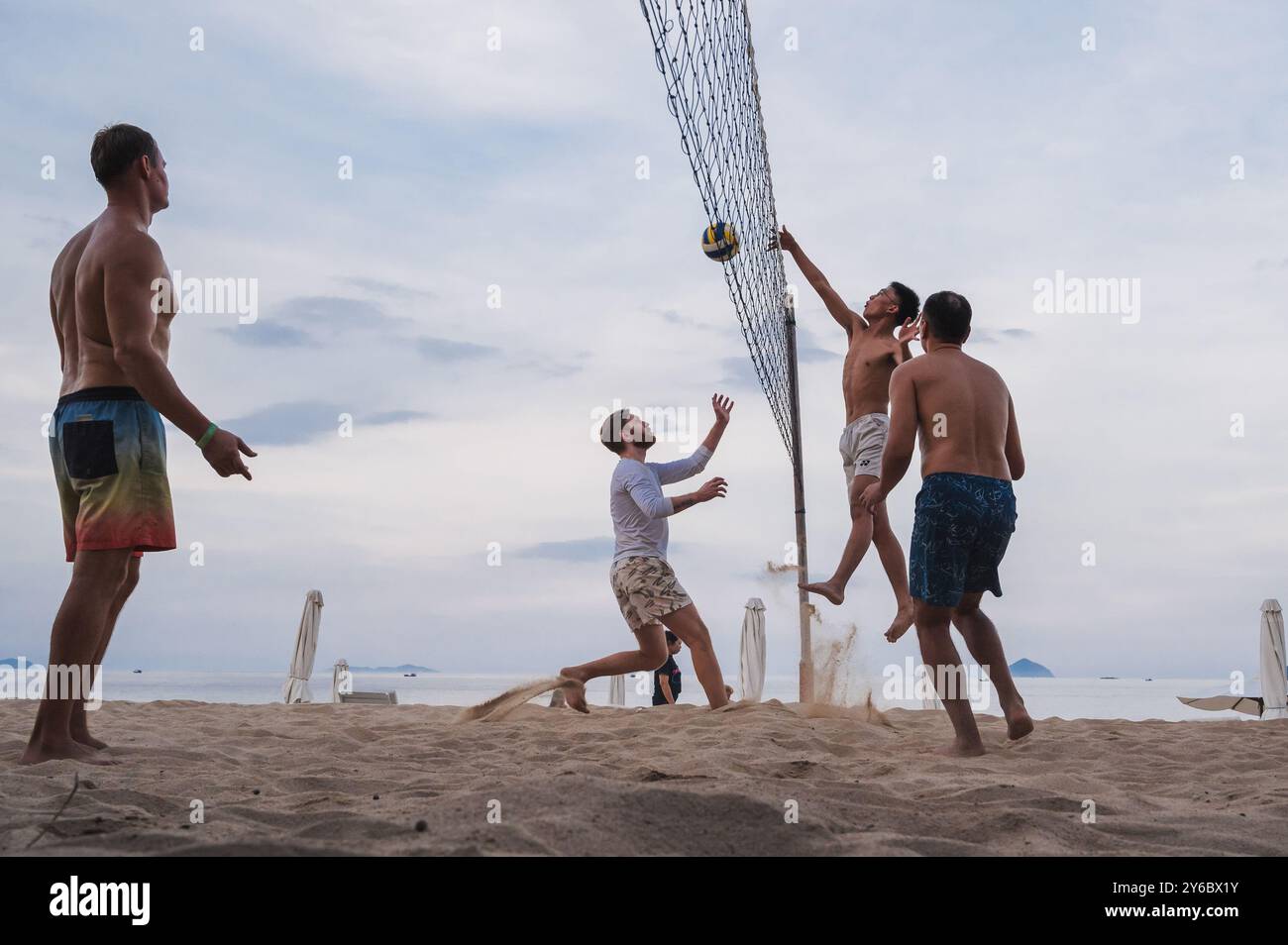 Teams with multinational players play beach volleyball by the sea in ...