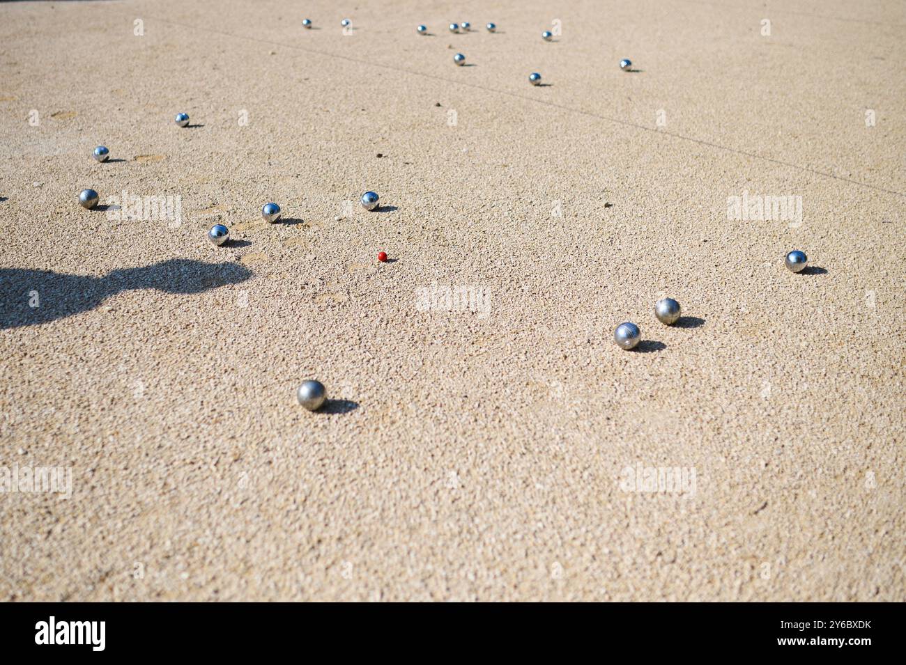 Close-up of petanque balls scattered on gravel with the target ball in ...