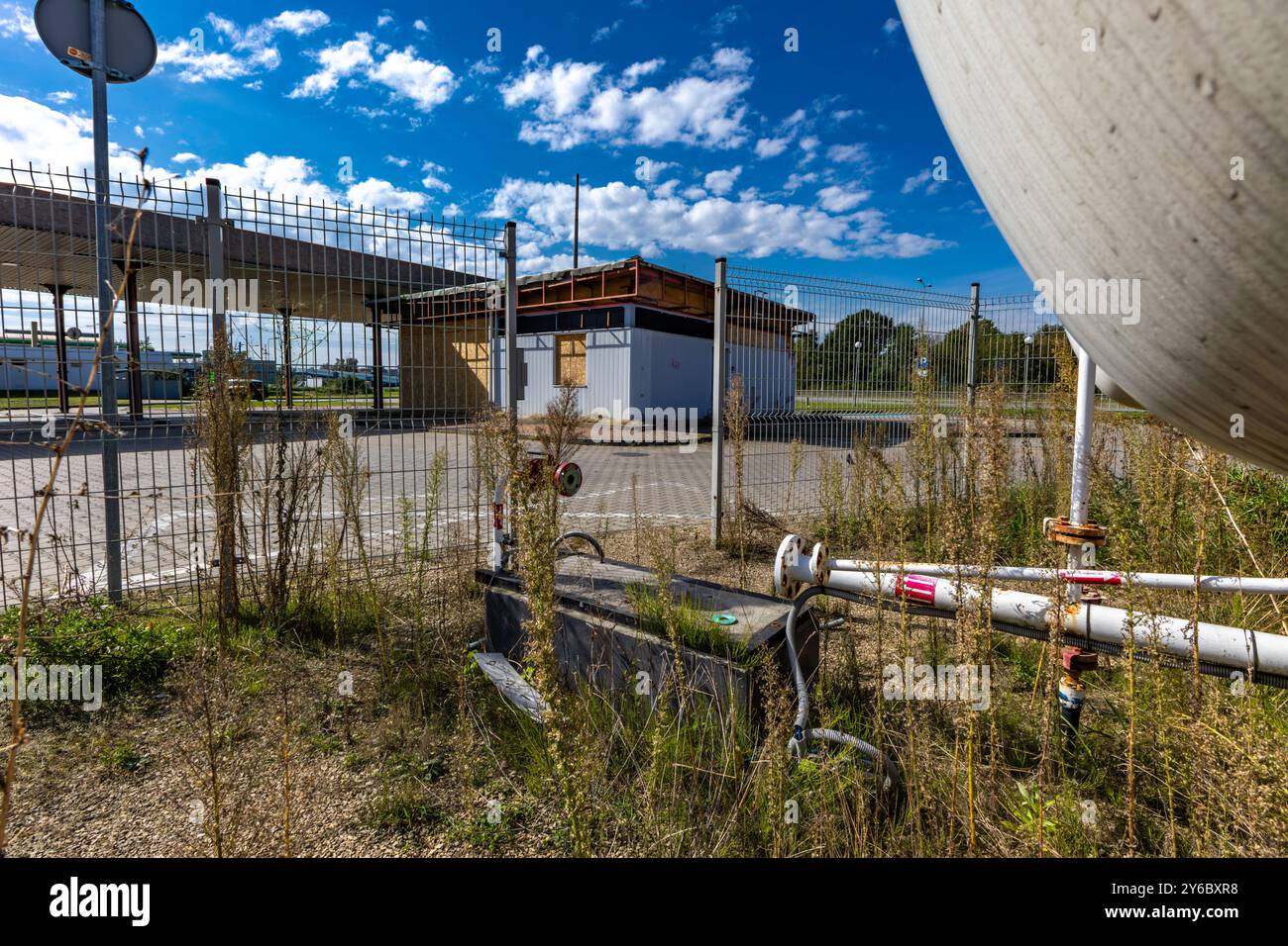 Inactive and abandoned gas station, inactive dispensers, boarded up ...