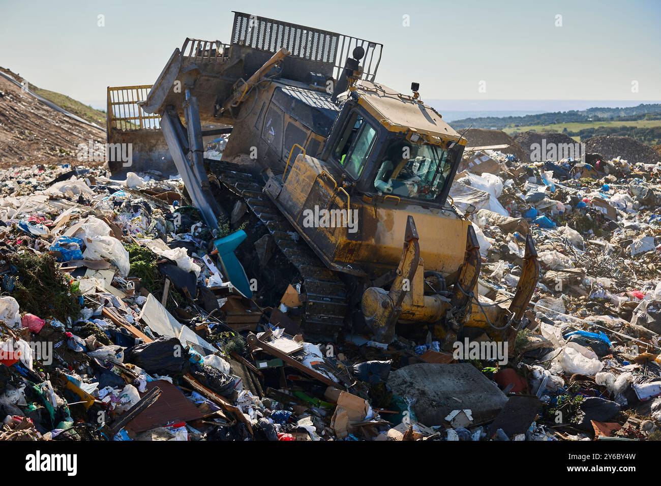 Heavy machinery shredding garbage in an open air landfill. Waste Stock ...