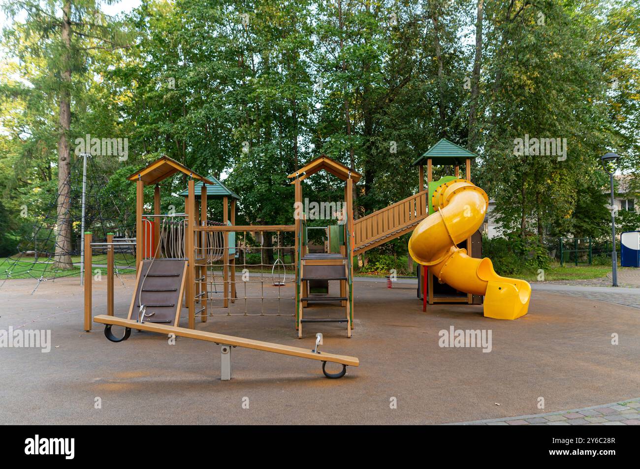 Bright park playground with climbing structures and slide surrounded by ...