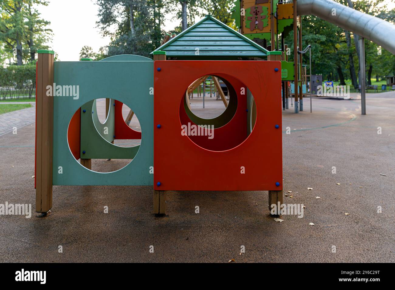 A playground area features a vibrant play structure in a park during ...