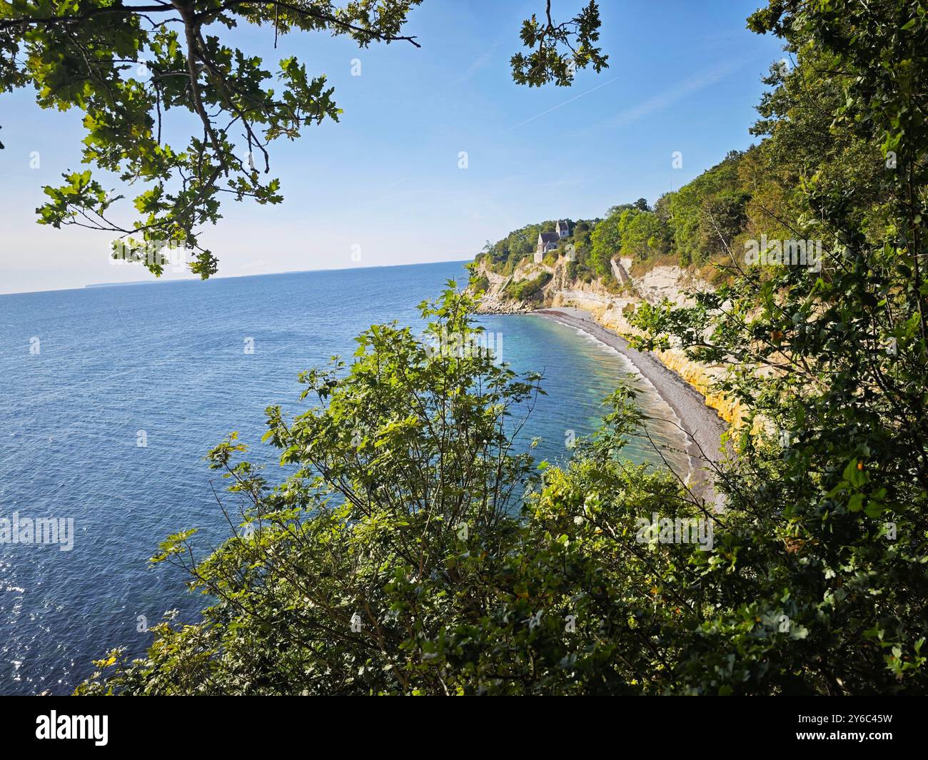 A scenic view of a coastal cliff with lush greenery and a clear blue ...