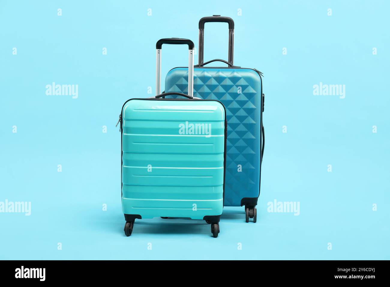 Different bright suitcases on light blue background Stock Photo - Alamy