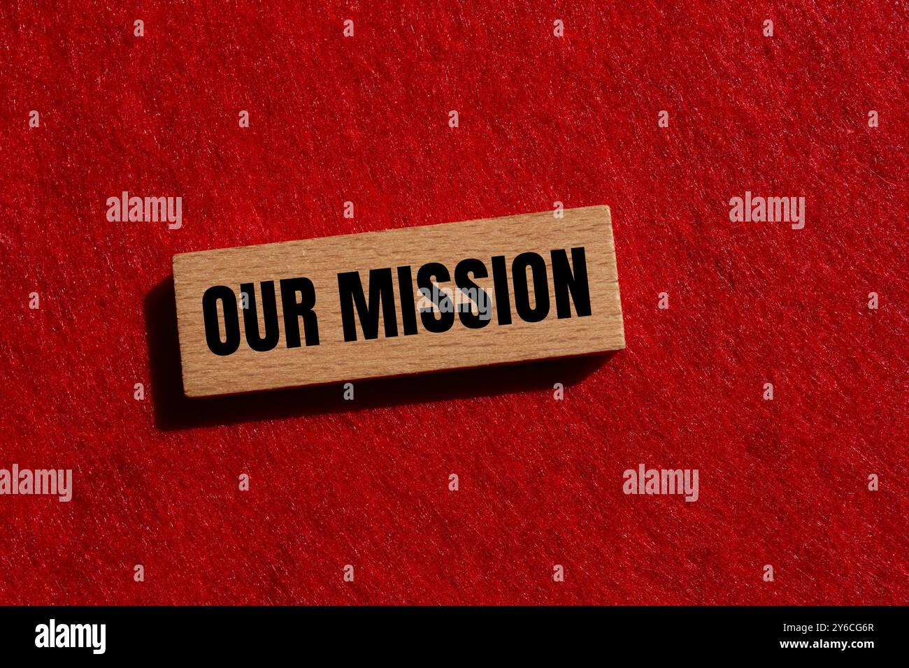Our mission message written on wooden block with red felt background ...