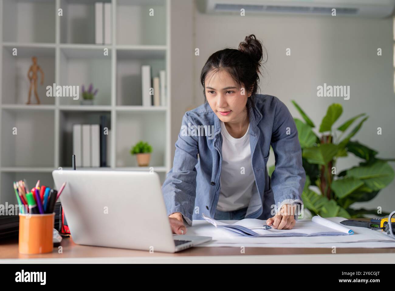 Dedicated Female Engineer Analyzing Project Layouts on Laptop Amid ...