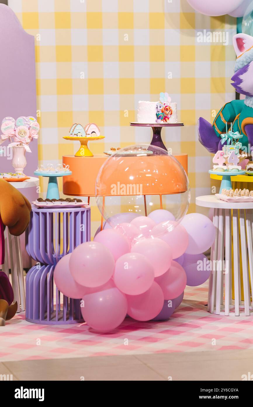 A colorful and whimsical birthday party setup with balloons, cakes, and ...