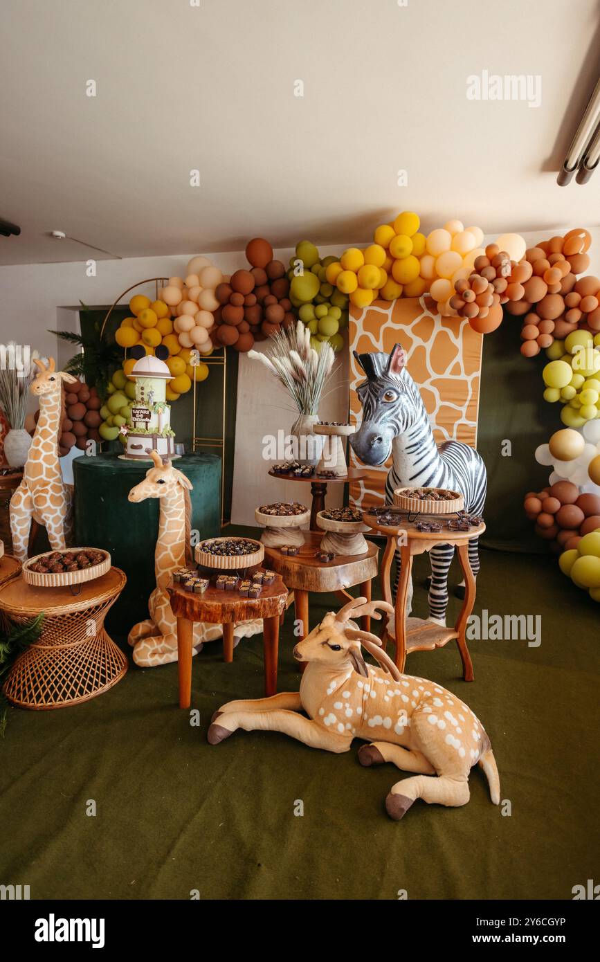 A safari-themed birthday party setup with stuffed animals, wooden ...