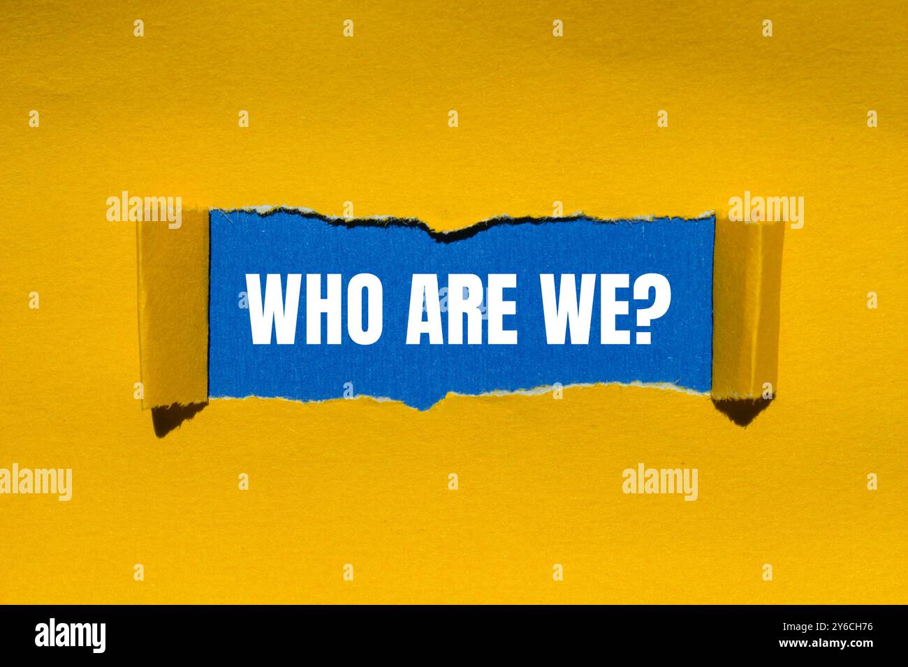 Who are we question message written on ripped torn yellow paper with ...