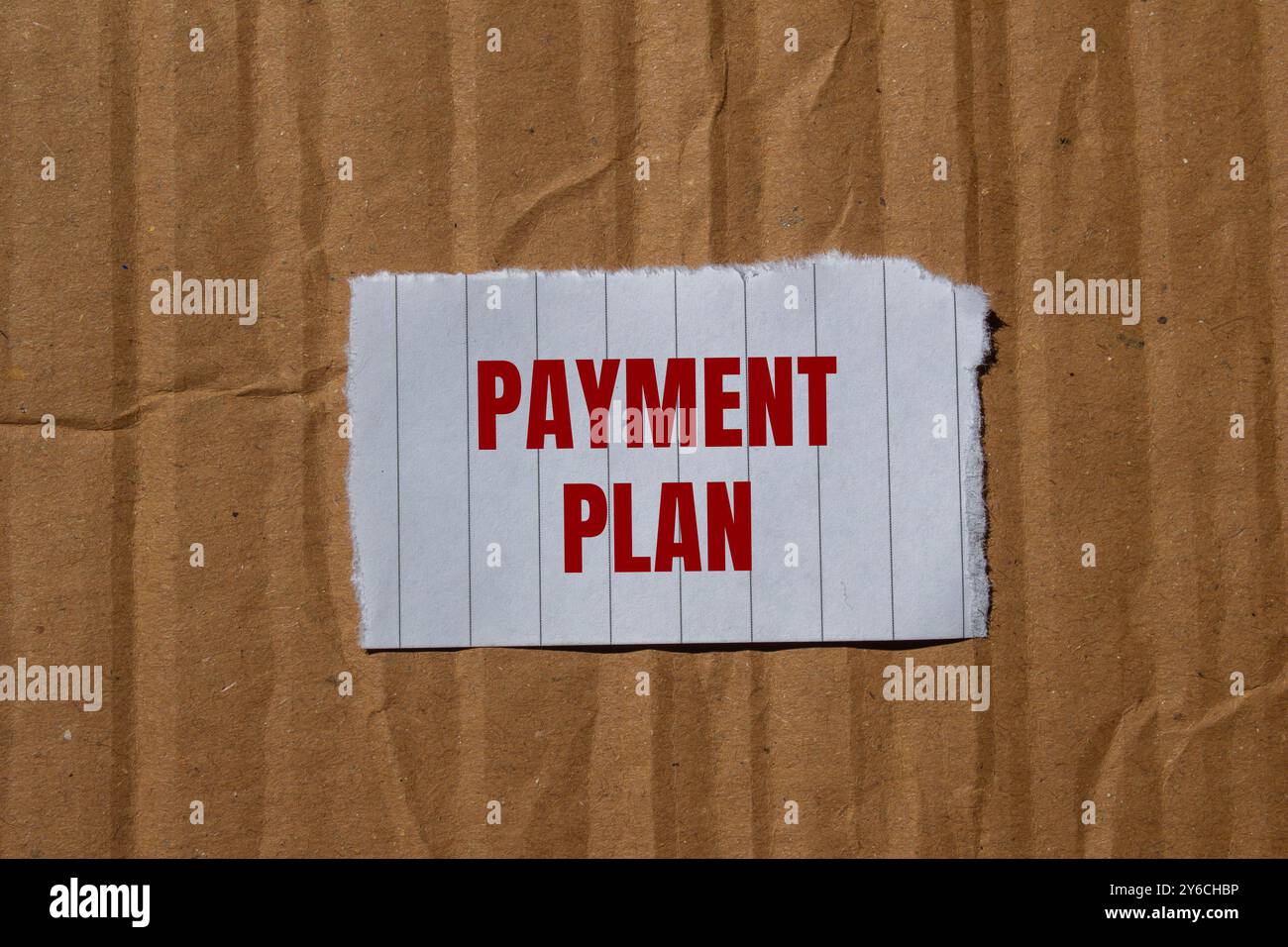 Payment plan message written on ripped torn paper with cardboard ...