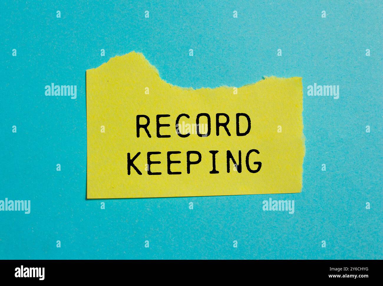 Record keeping message written on ripped torn yellow paper with blue background. Conceptual ...